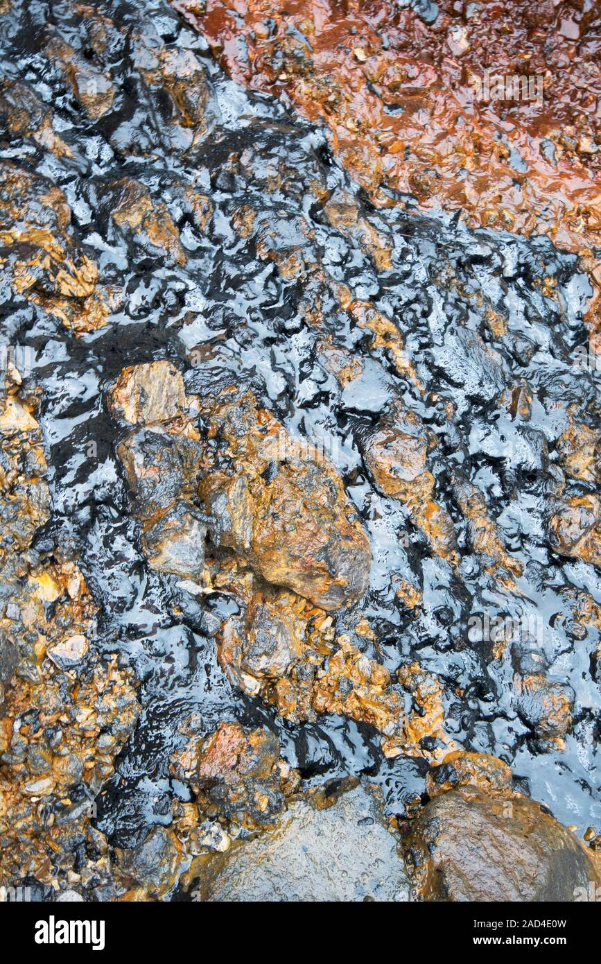 Natural oil seep. View of oil seeping from between rocks at a quarry in ...