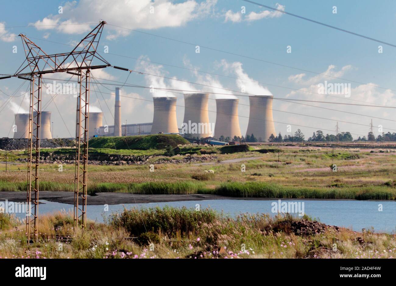 Hendrina Power Station. View past powerlines and a polluted dam ...