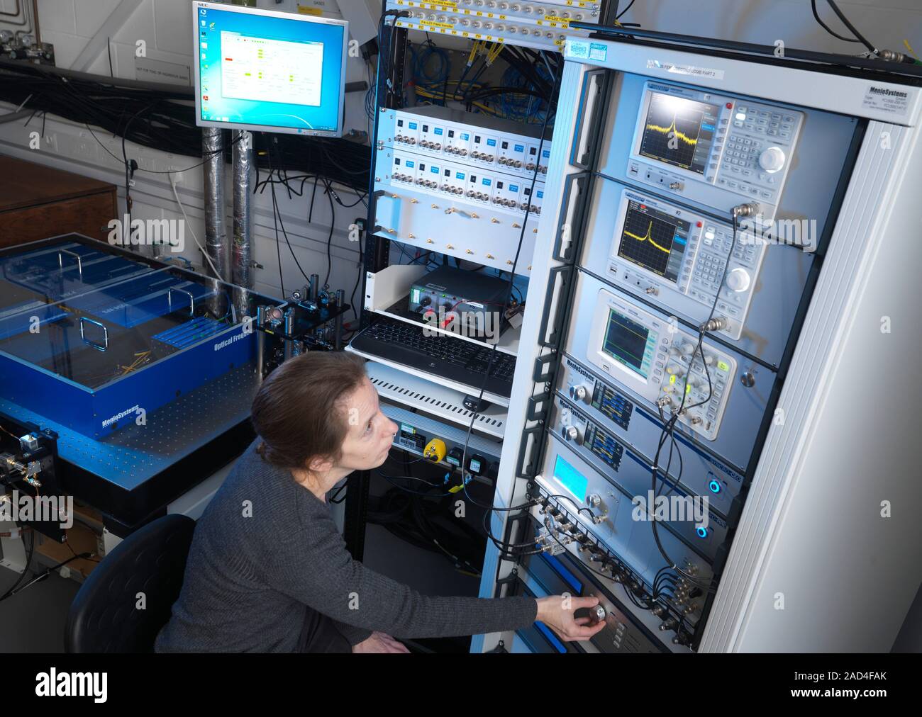 Femtosecond optical frequency comb. Researcher working with one of the ...
