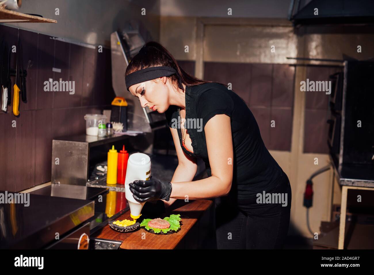 beautiful girl Cook prepares the kitchen Burger Stock Photo - Alamy