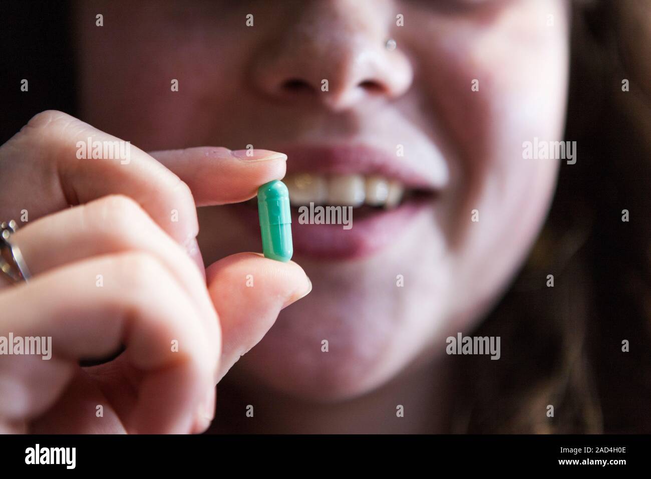 Student testing drugs. University student holding a drug capsule that ...