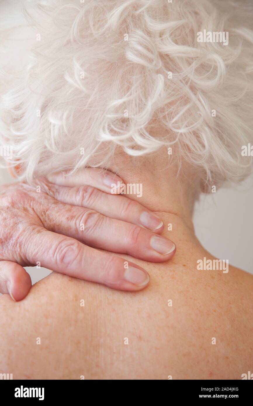 Elderly woman with neck pain. 81-year-old woman holding her painful ...
