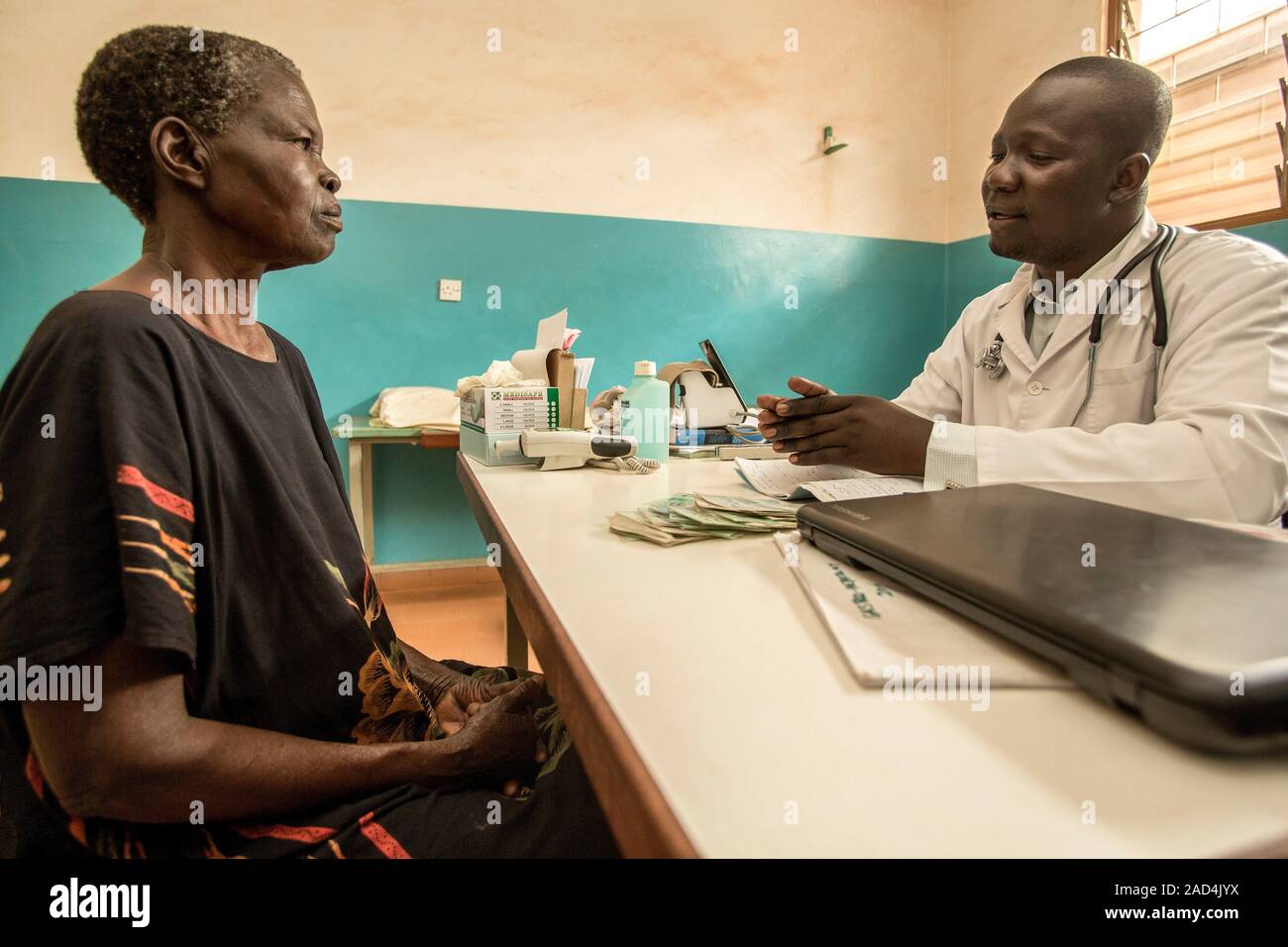 Hospital consultation. Hospital doctor talking to a patient to assess ...