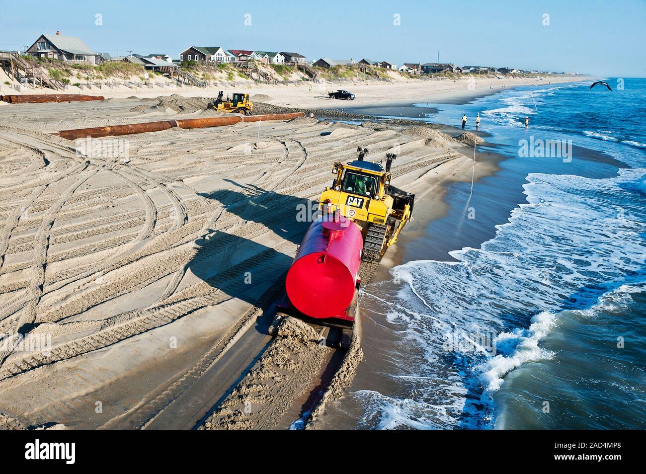 Beach conservation. Diggers being used to rebuild eroded beaches at ...