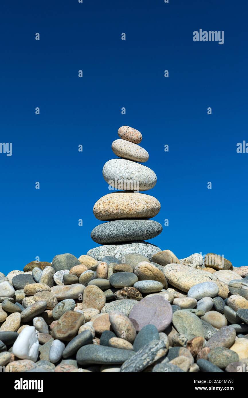 Cairn. Cairn amongst other rocks on a beach. Cairns are piles of stones ...