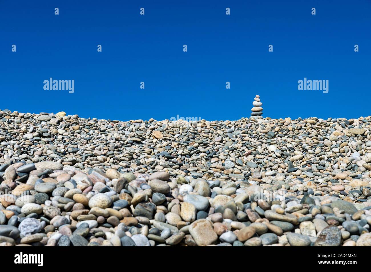 Cairn. Cairn amongst other rocks on a beach. Cairns are piles of stones ...