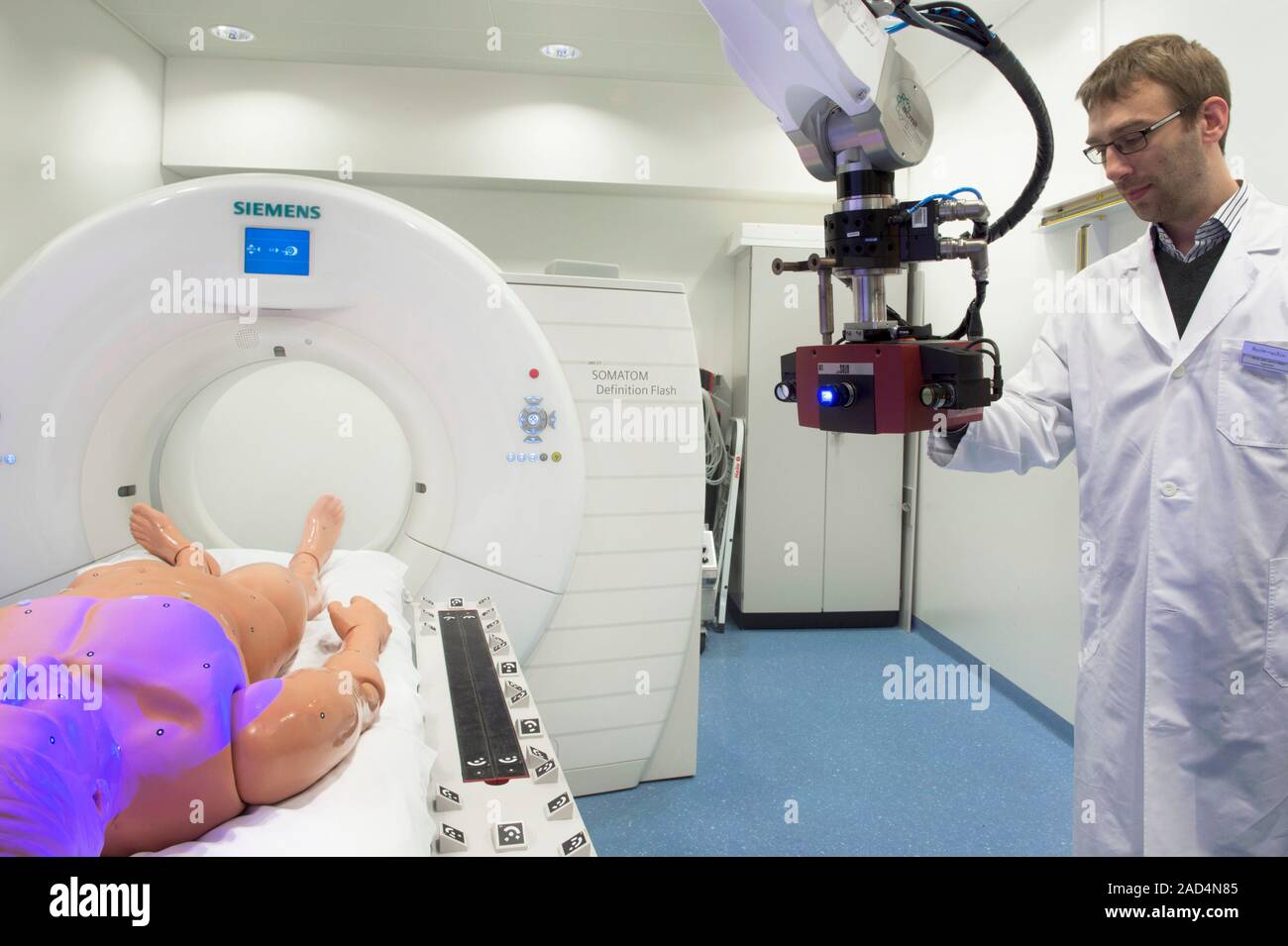 Virtopsy robot scanner. Mannequin corpse being scanned in blue light by ...