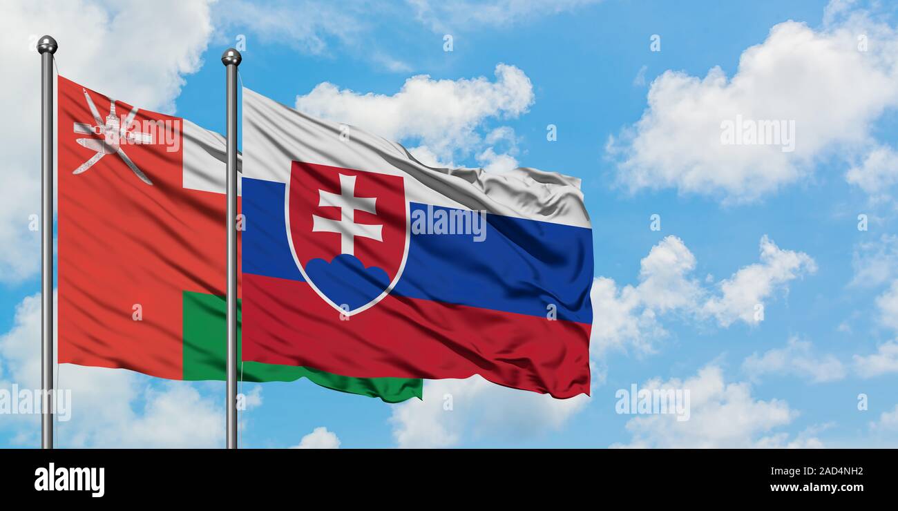 Oman and Slovakia flag waving in the wind against white cloudy blue sky ...