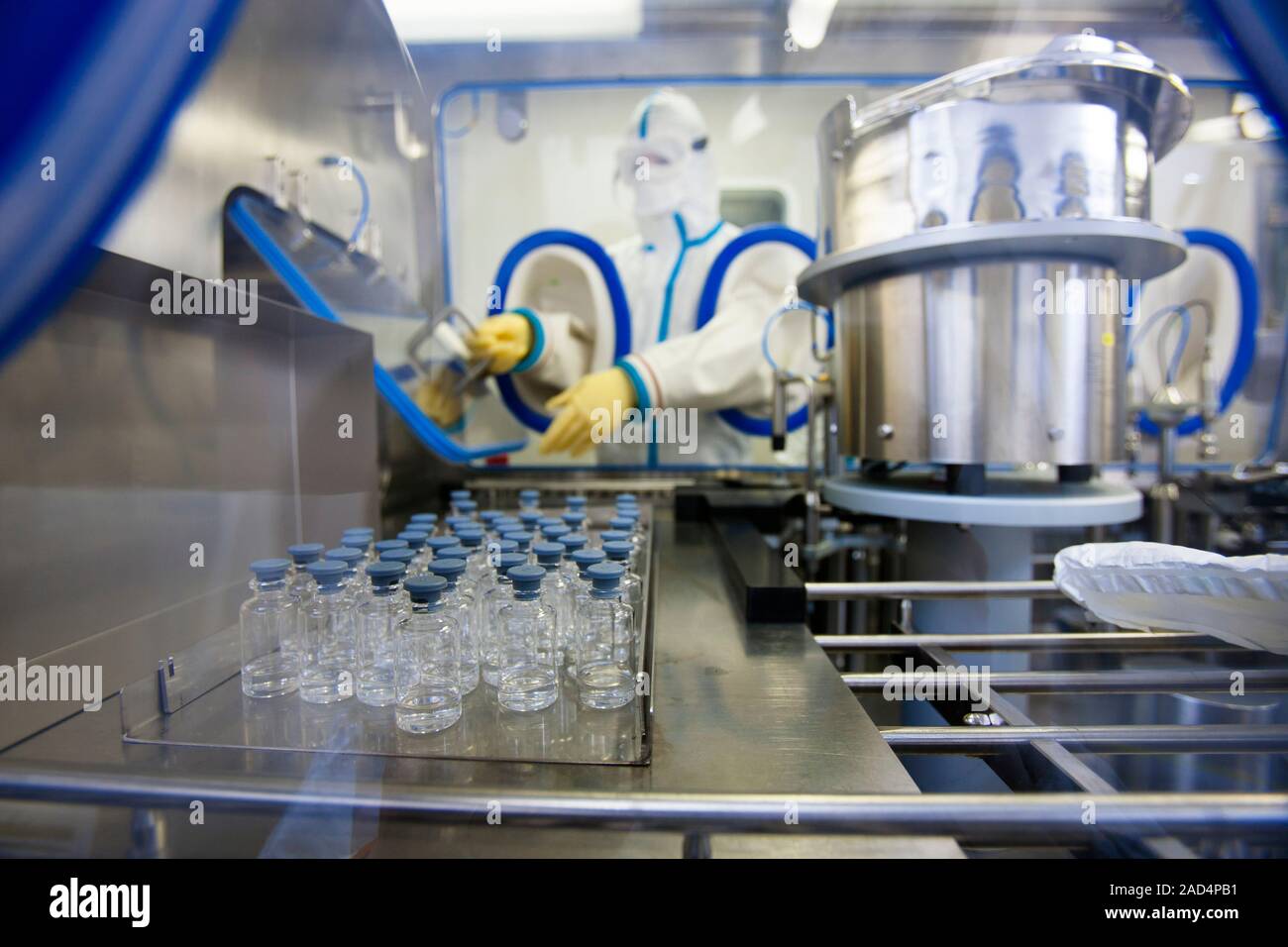 Drug manufacturing. Laboratory worker carrying out aseptic filling of ...