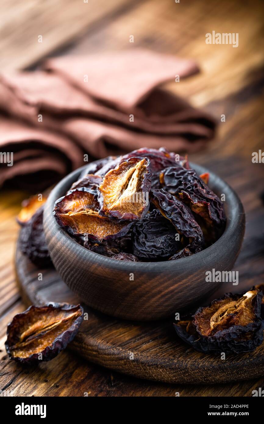Prune, dried plums fruits on dark rustic wooden background Stock Photo ...