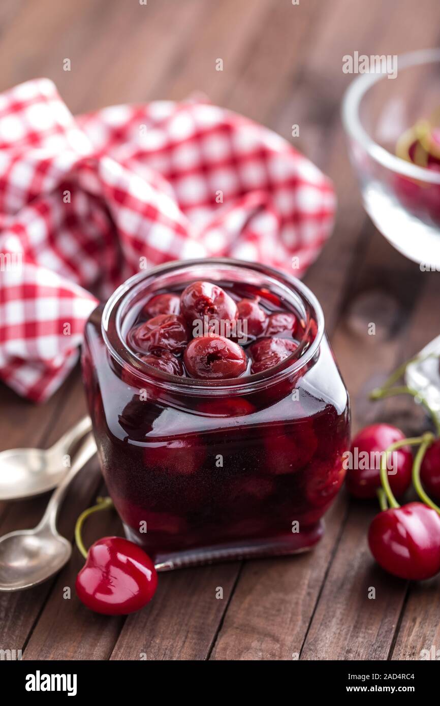 Berries cherry with syrup in a glass jar. Canned fruit Stock Photo - Alamy