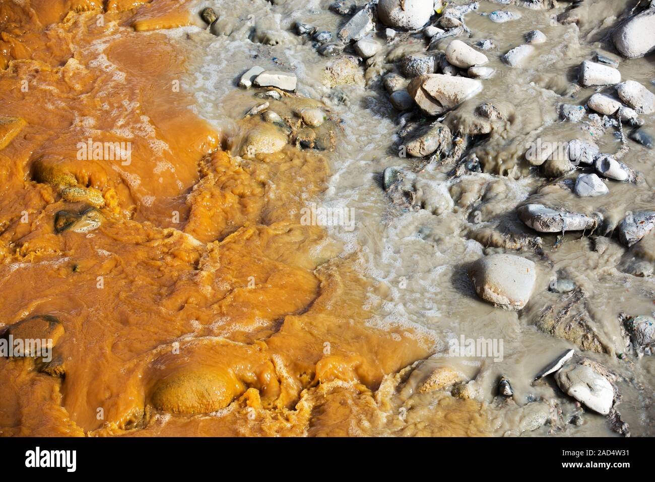 A river full of water contaminated by mine effluent, mixing with raw ...