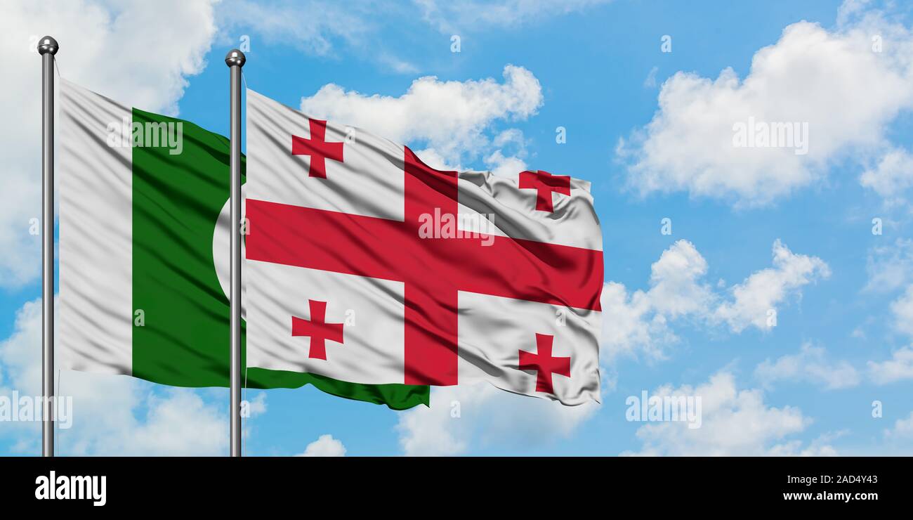 Pakistan and Georgia flag waving in the wind against white cloudy blue ...