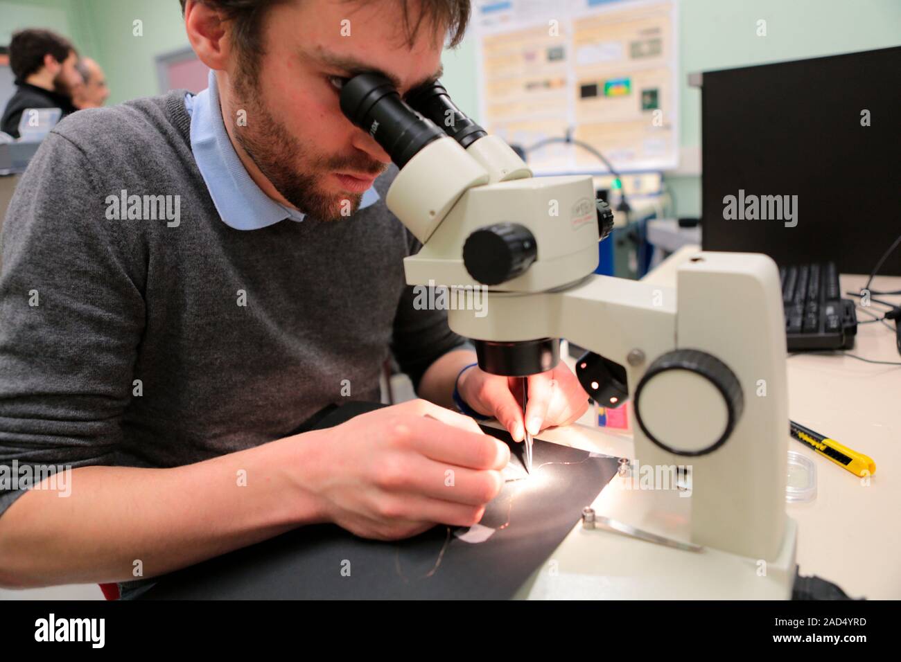 Insect nanodrone research. A researcher works on microscopic components ...
