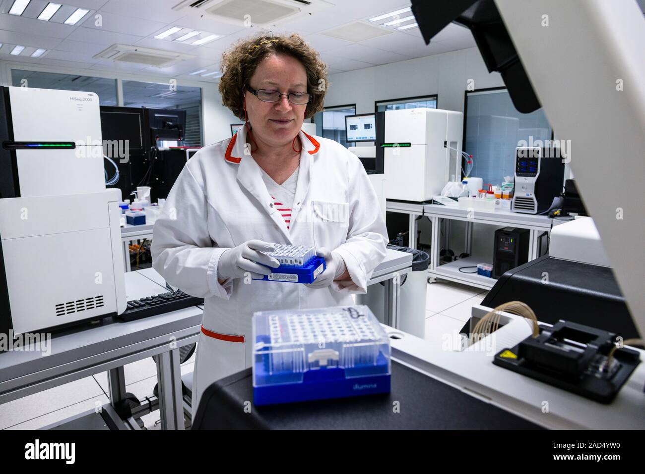 Automated DNA amplification. A technician prepares samples to be placed ...