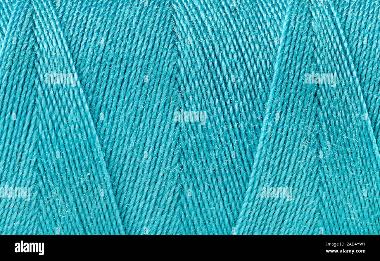 Blue thread spooled on a bobbin Stock Photo - Alamy