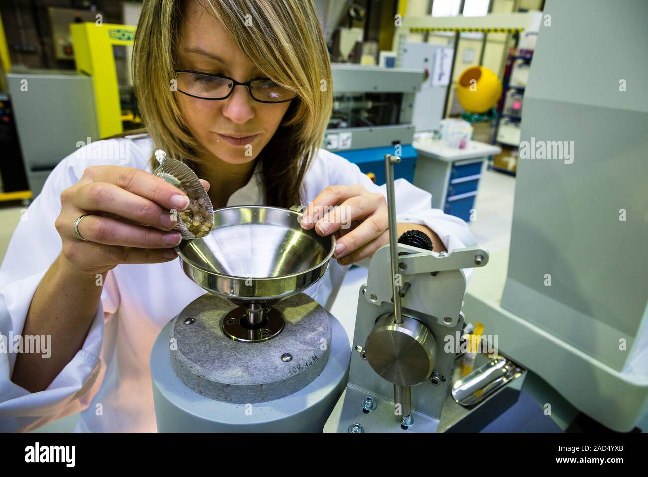 Quality control of recycled plastics. A technician conducting fluidity ...