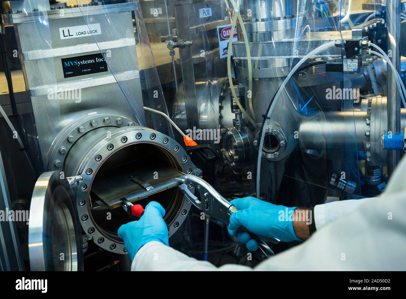 Thin-film photovoltaic cell research. A researcher places a thin-film ...