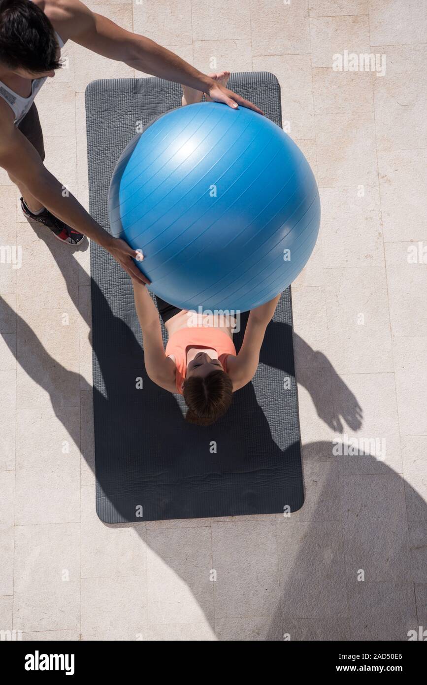 woman and personal trainer doing exercise with pilates ball Stock Photo ...
