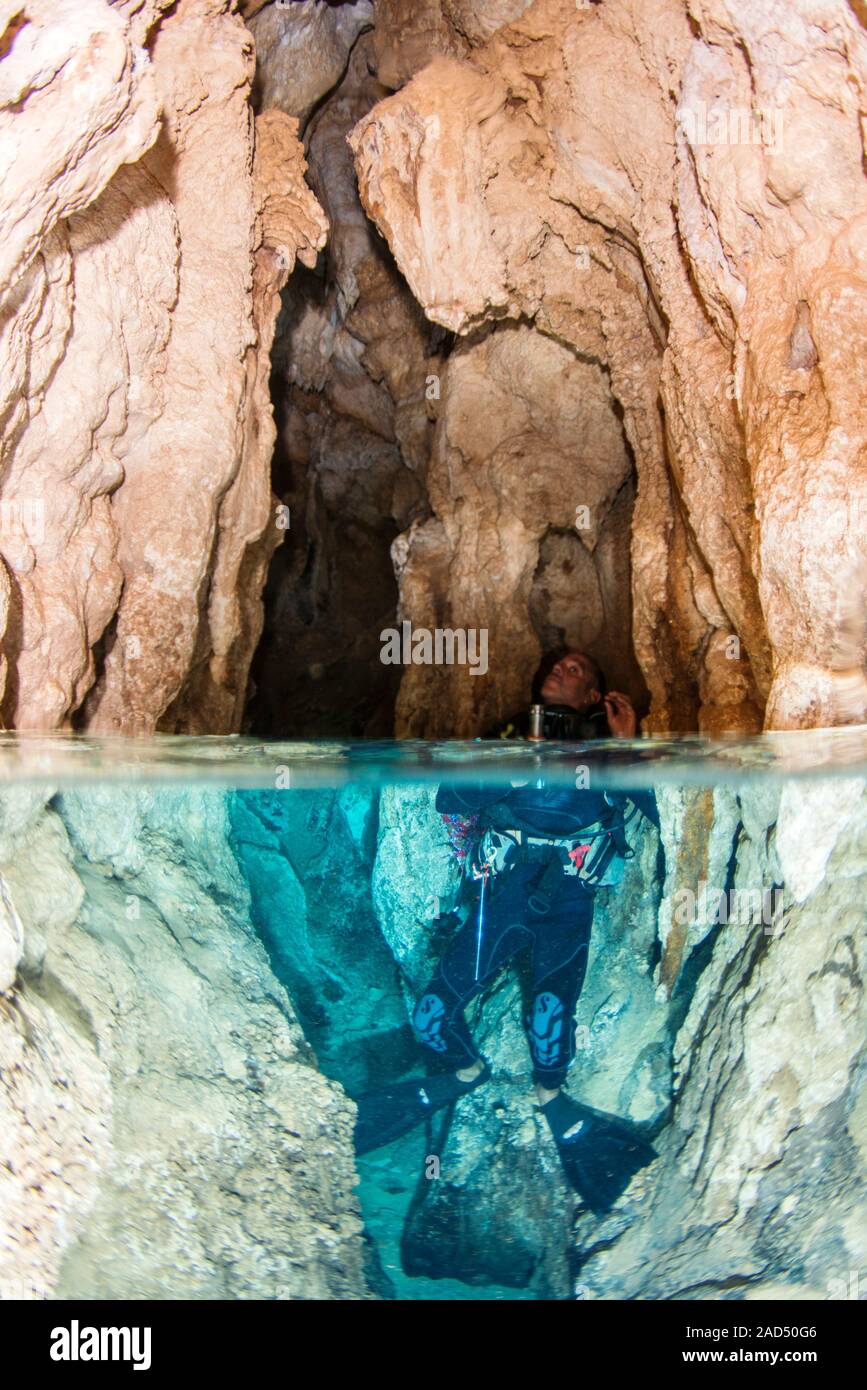 A scuba diver exploring Chandelier cave. Photographed at Palau islands ...