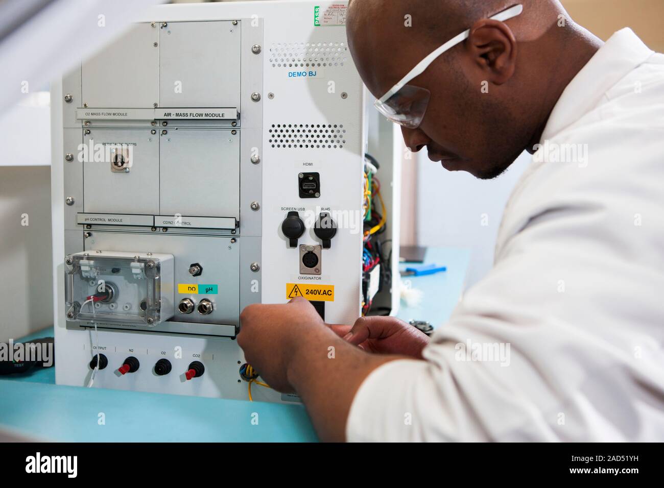 Bioreactor construction. Technician building a bioreactor system. This ...