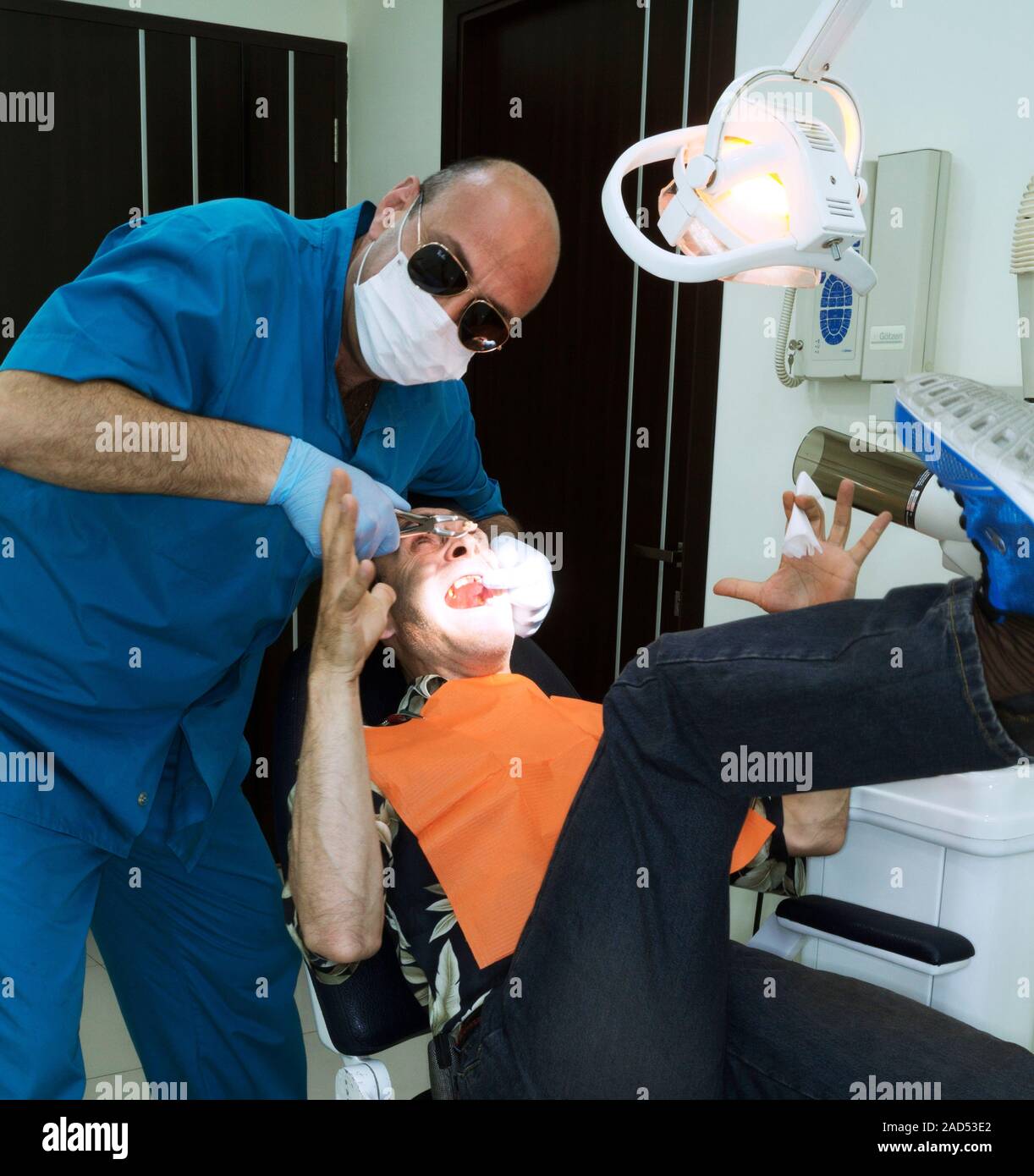 Tooth extraction. Dentist extracting a patient's tooth Stock Photo - Alamy