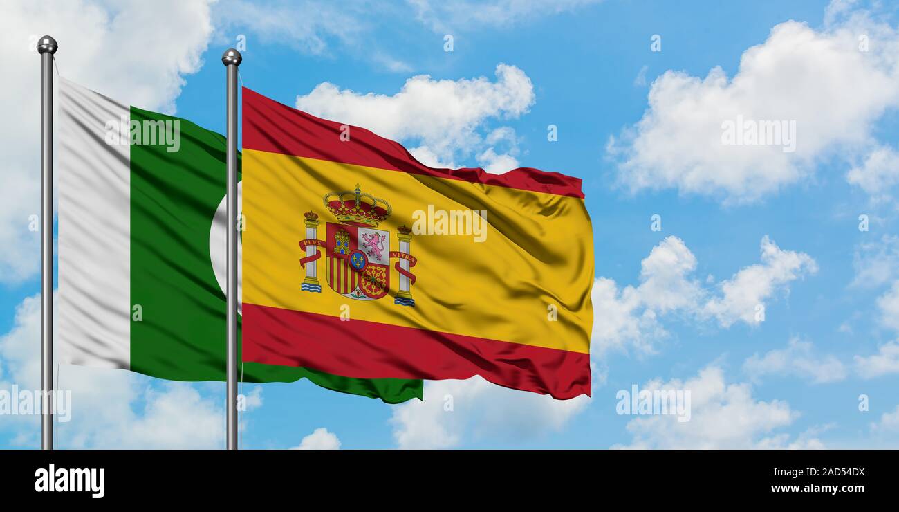 Pakistan and Spain flag waving in the wind against white cloudy blue ...