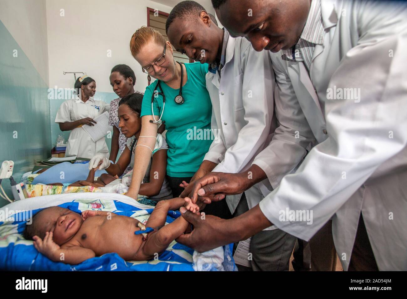 Hospital doctors examining newborn babies and testing their reflexes ...