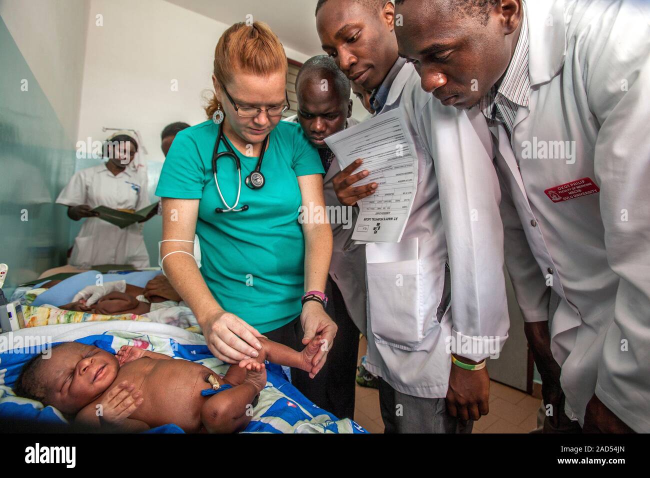 Hospital doctors examining newborn babies and testing their reflexes ...