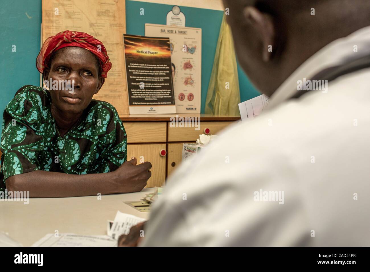 Hospital consultation. Hospital doctor talking to a patient to assess ...