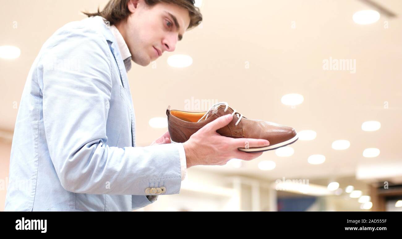 Man Chooses Shoes At Shoe Store Stock Photo - Alamy