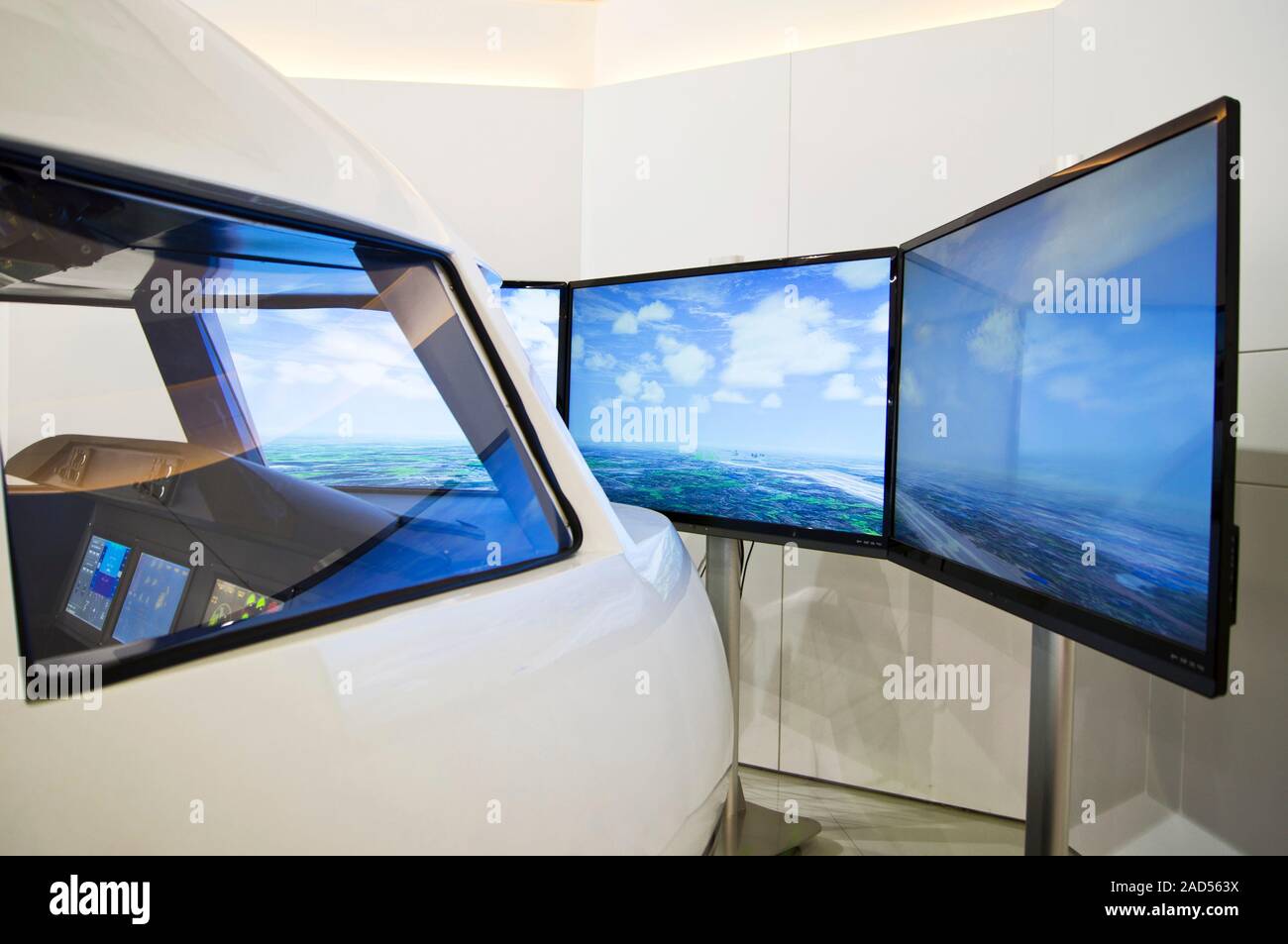 An aircraft flight simulator with three separate TV screens outside the ...