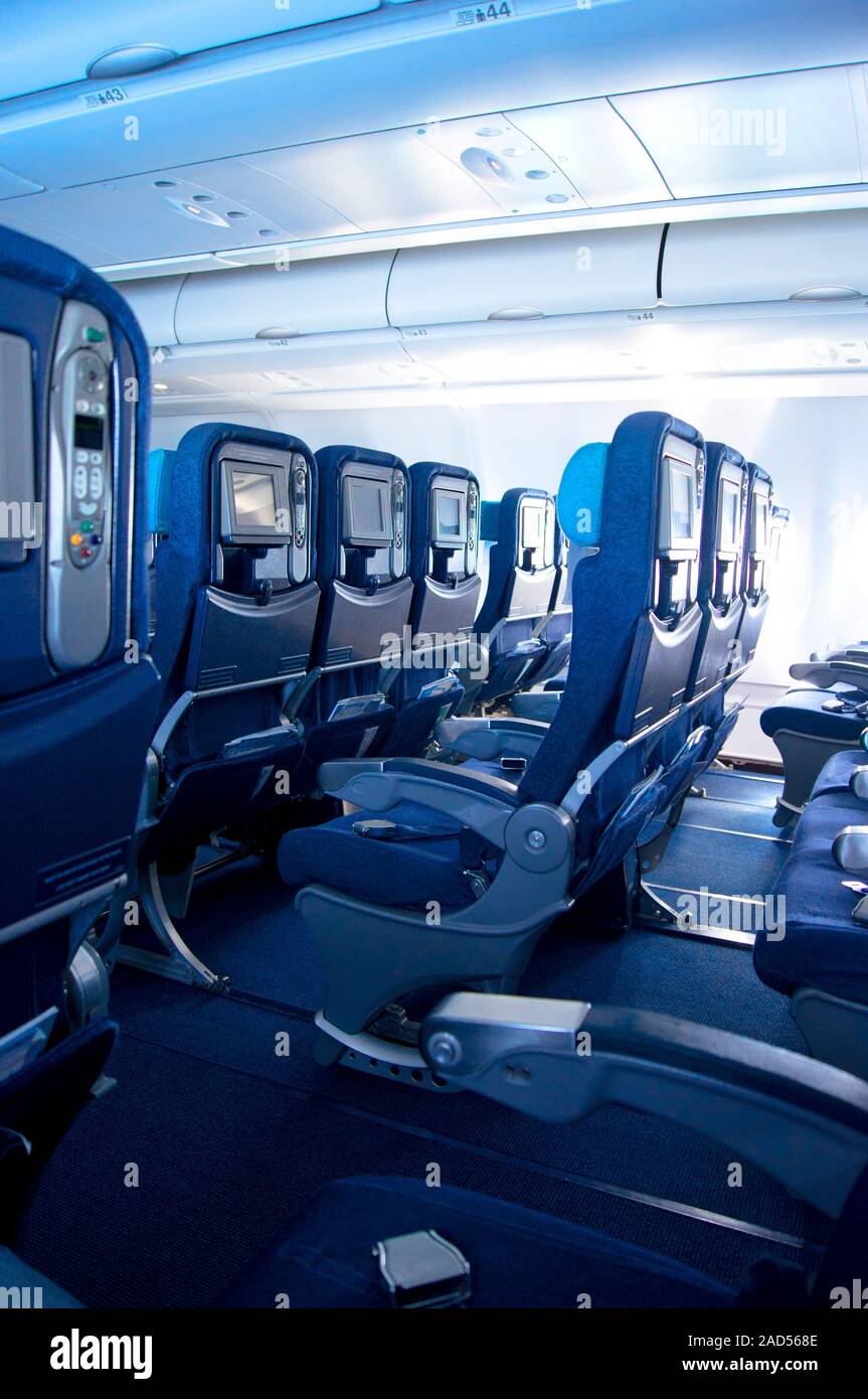 Several rows of economy class seating in a chartered passenger aircraft ...