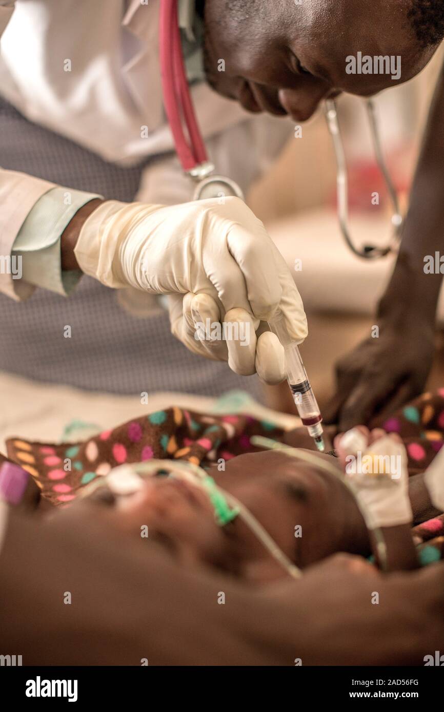 Taking blood sample. Doctor taking a blood sample from a baby in a ...