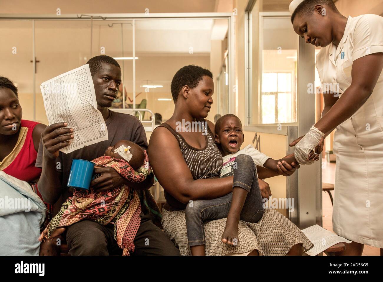 Nurse performing an injection. Crying boy with his mother, being given ...