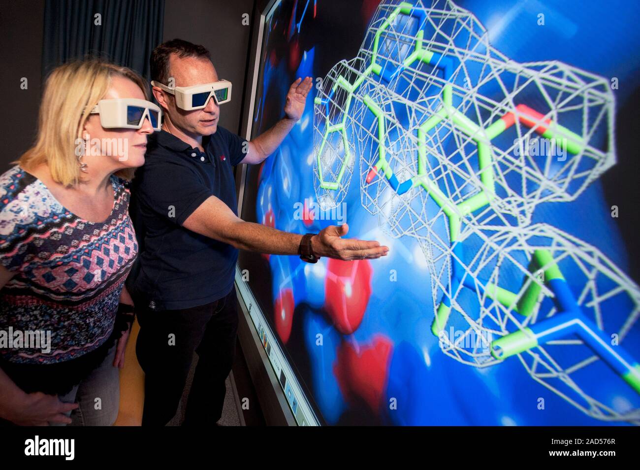 3D anti-cancer drug design. Two researchers look at a 3D visualisation ...