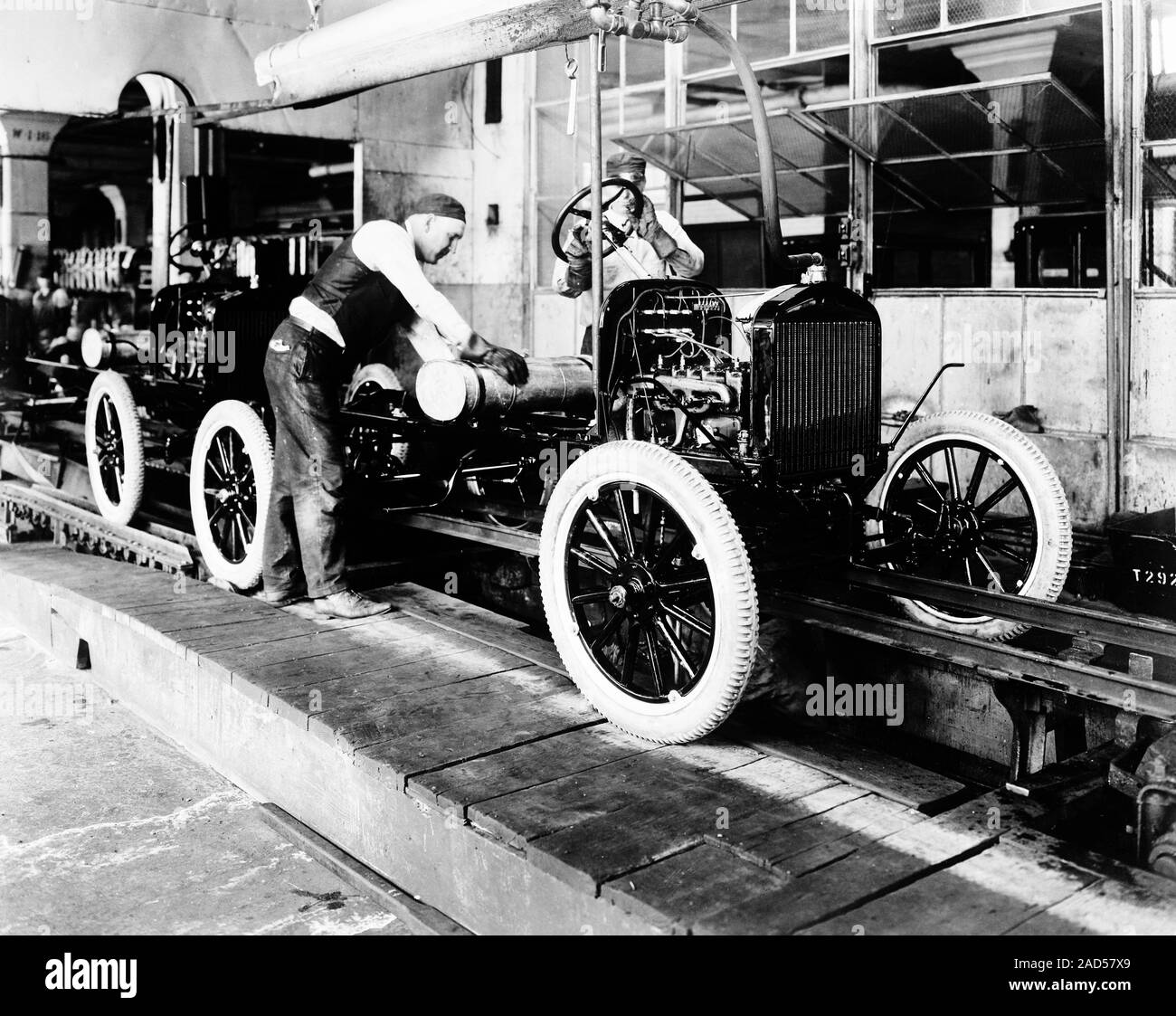 Car factory production line. Car assembly line workers constructing a ...