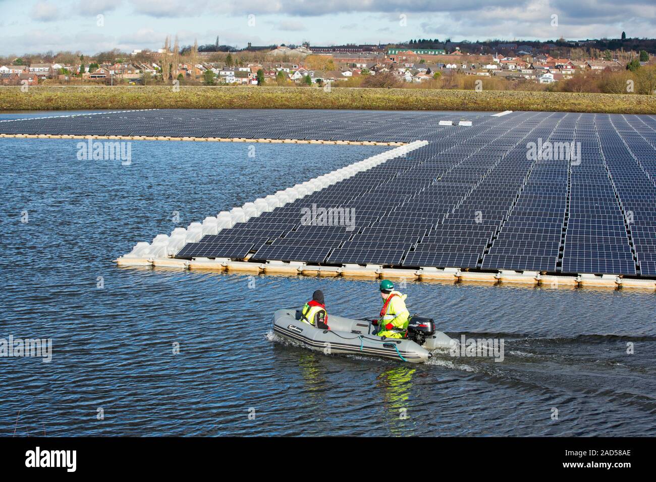 Floating solar farm being connected on Godley Reservoir, Hyde, Manchester, UK. As of 2016 this ...