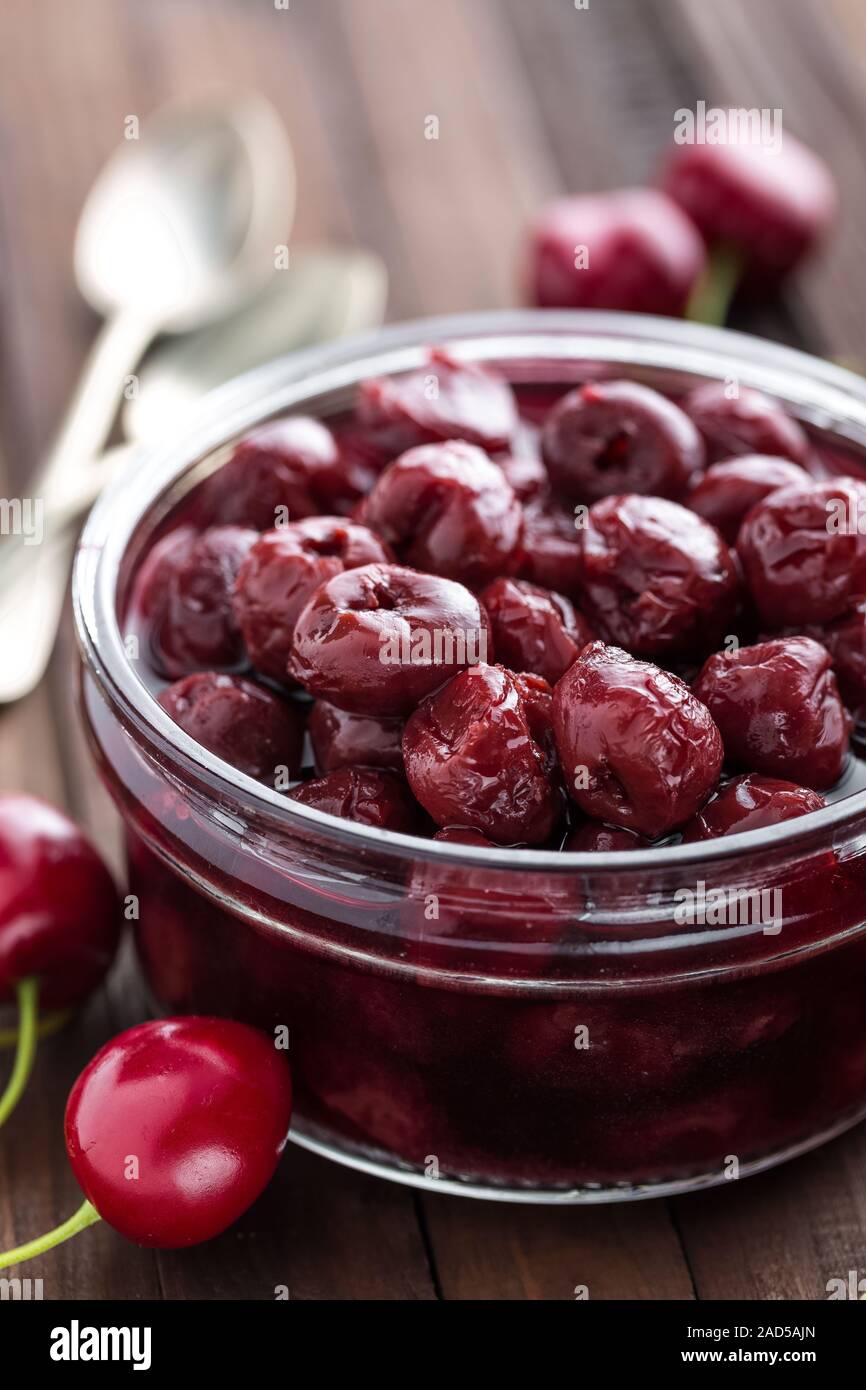 Berries cherry with syrup in a glass jar. Canned fruit Stock Photo - Alamy