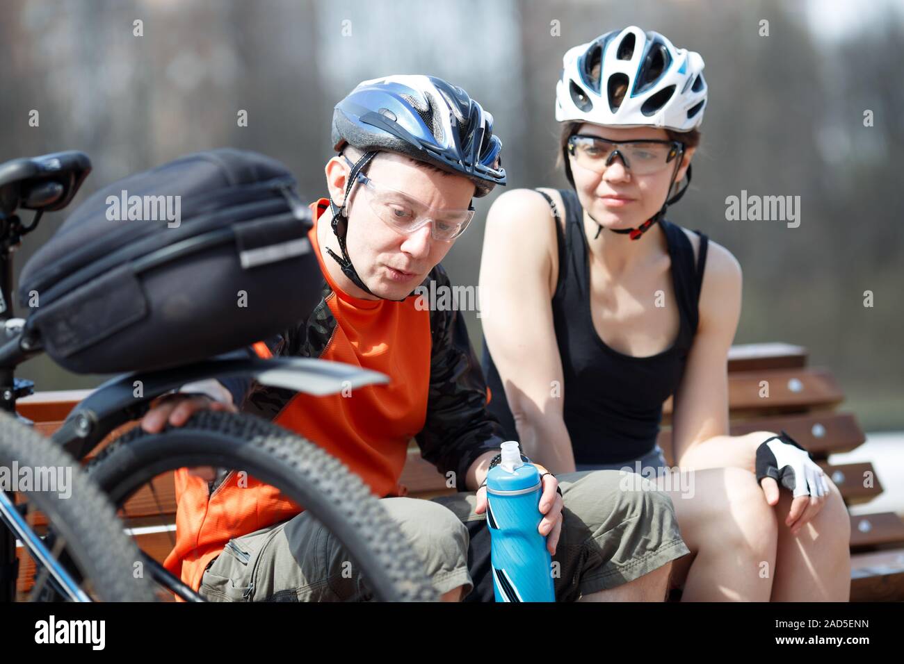 Two bikers rest on bench Stock Photo - Alamy