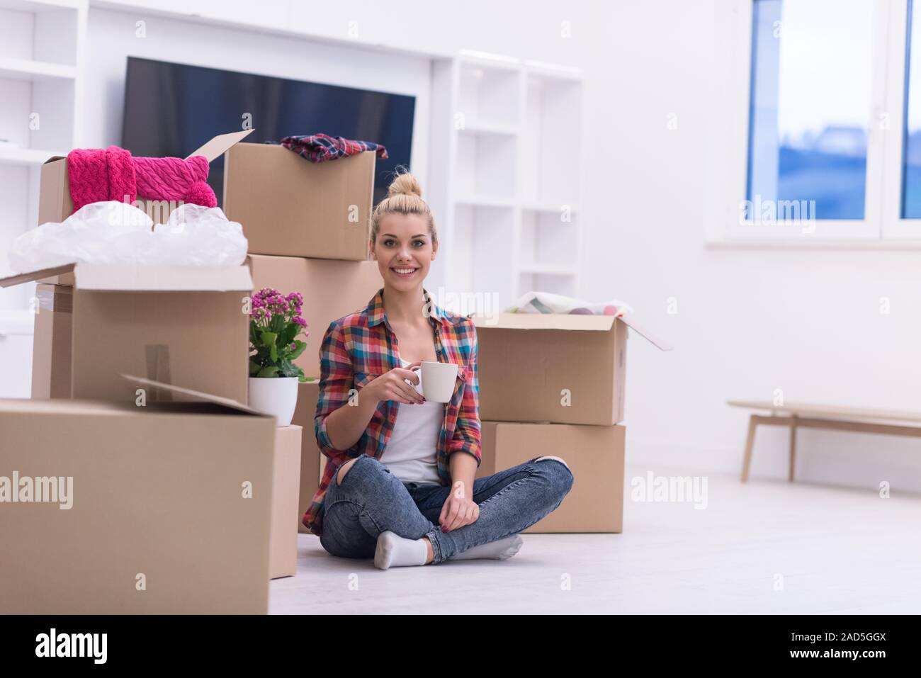 woman with many cardboard boxes sitting on floor Stock Photo - Alamy