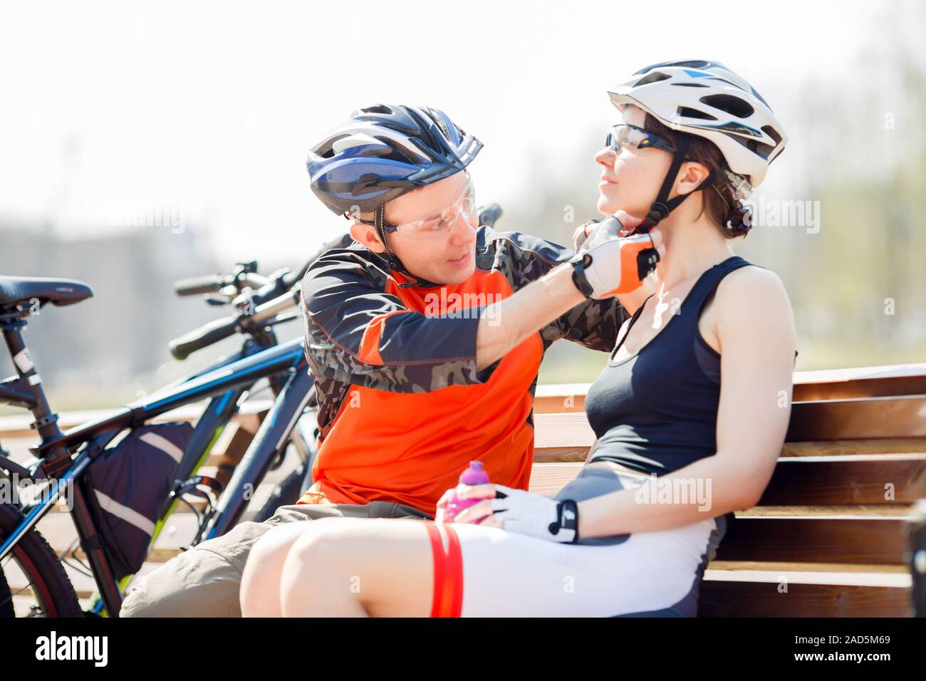 Two cyclists putting on helmet Stock Photo - Alamy