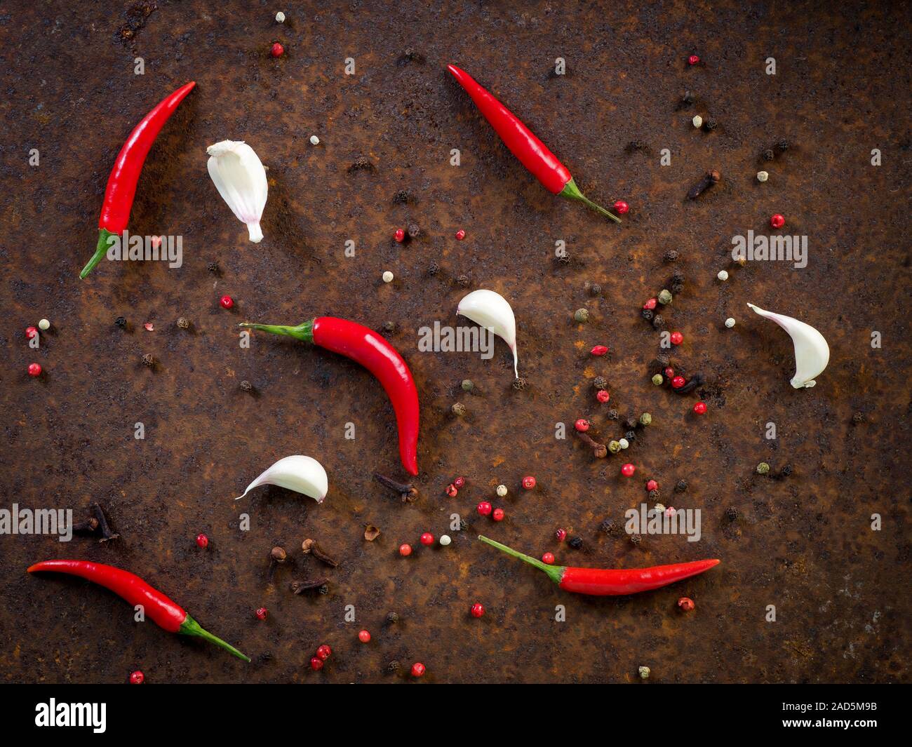 red hot chili pepper pods and peas, garlic clove on dark rusty metal ...