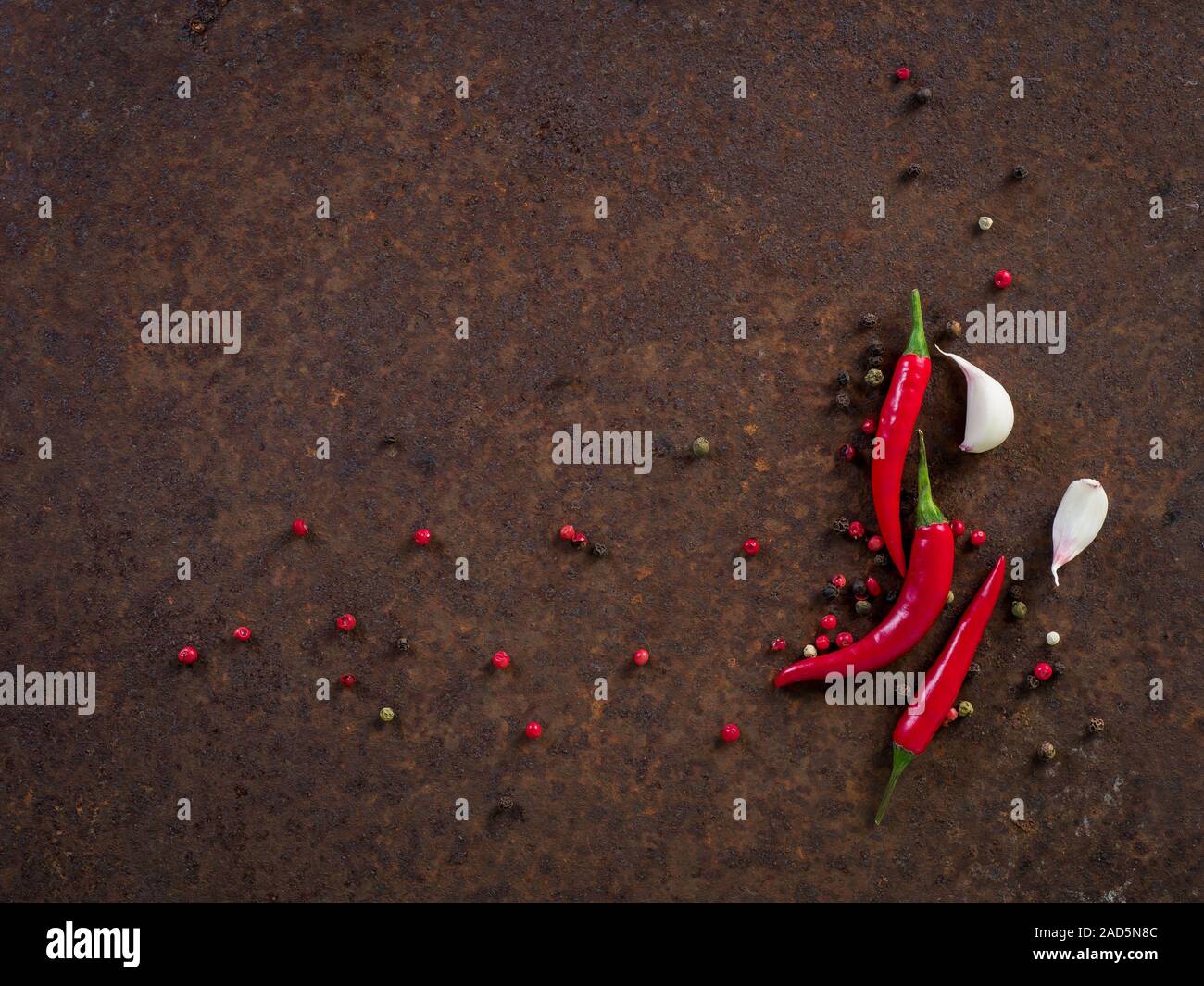 red hot chili pepper pods and peas, garlic clove on dark rusty metal ...