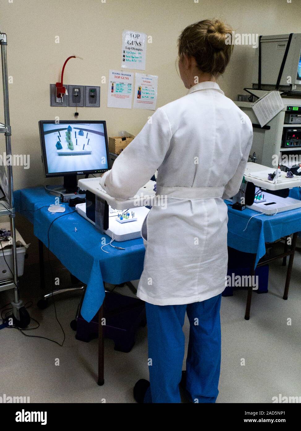 Laparoscopy training session. Surgical resident using a laparoscopic ...