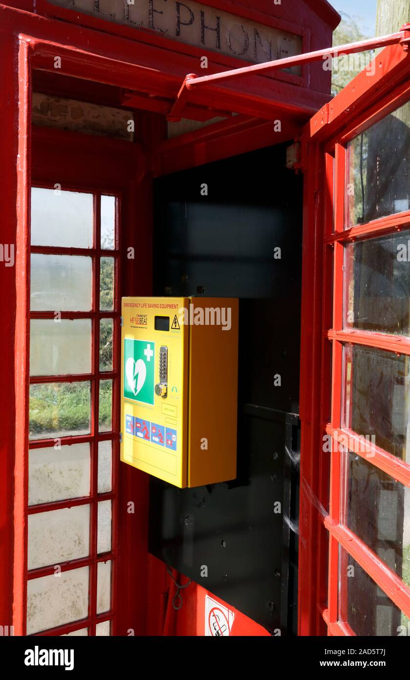 Community defibrillator in red telephone kiosk. The yellow cabinet ...