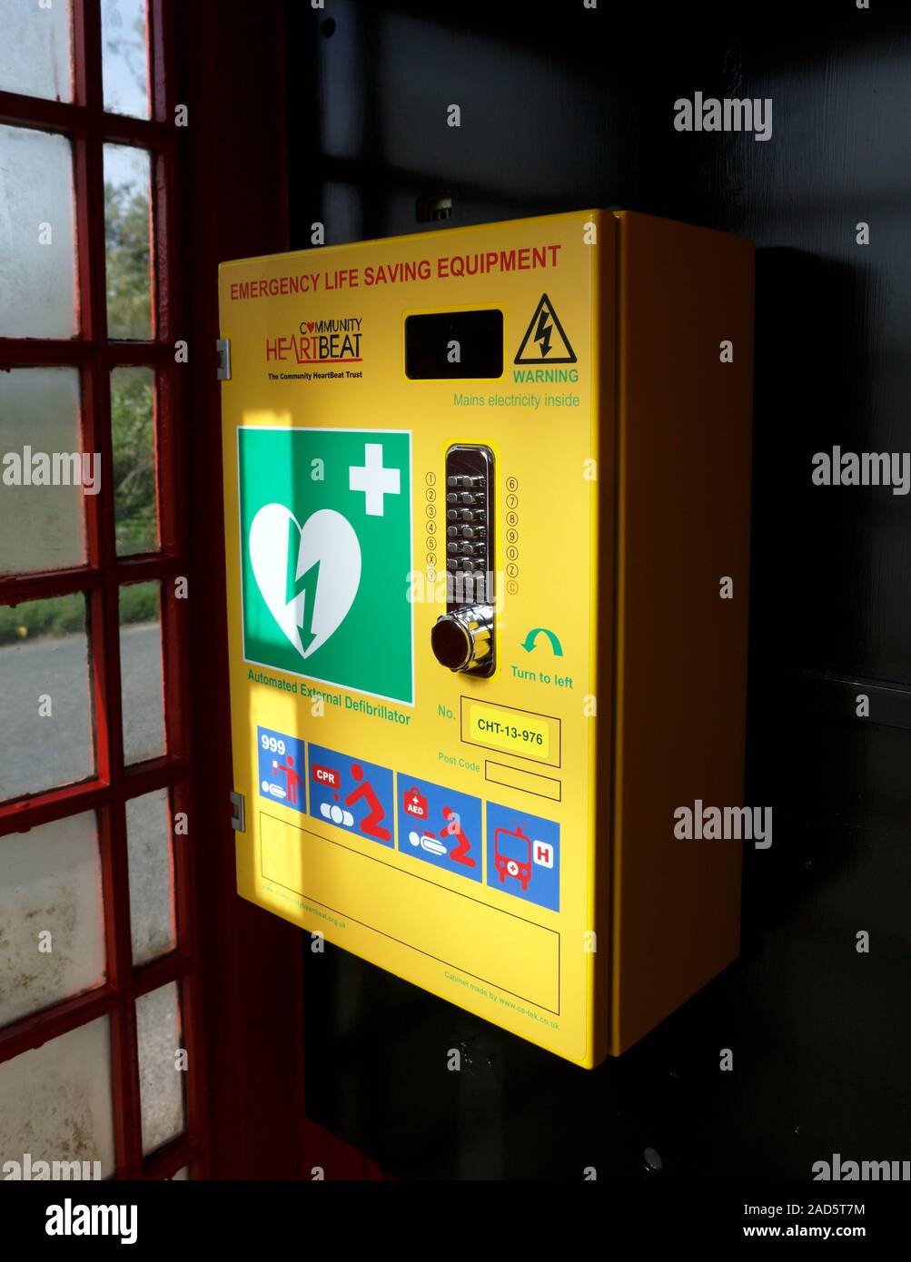 Community defibrillator in red telephone kiosk. The yellow cabinet ...