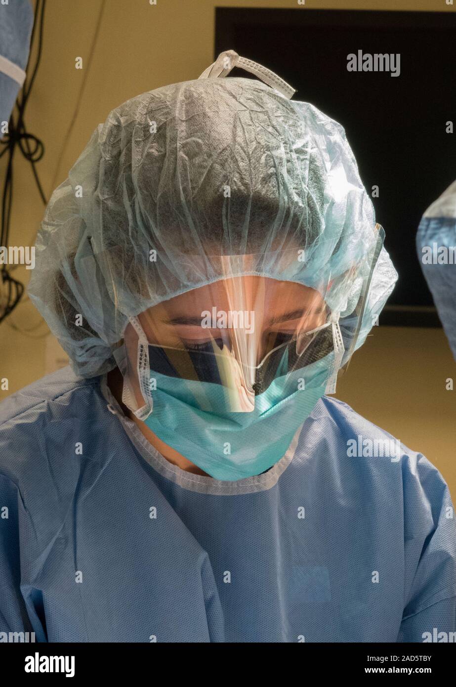 Surgeon at work. Surgeon wearing a protective facemask while operating ...