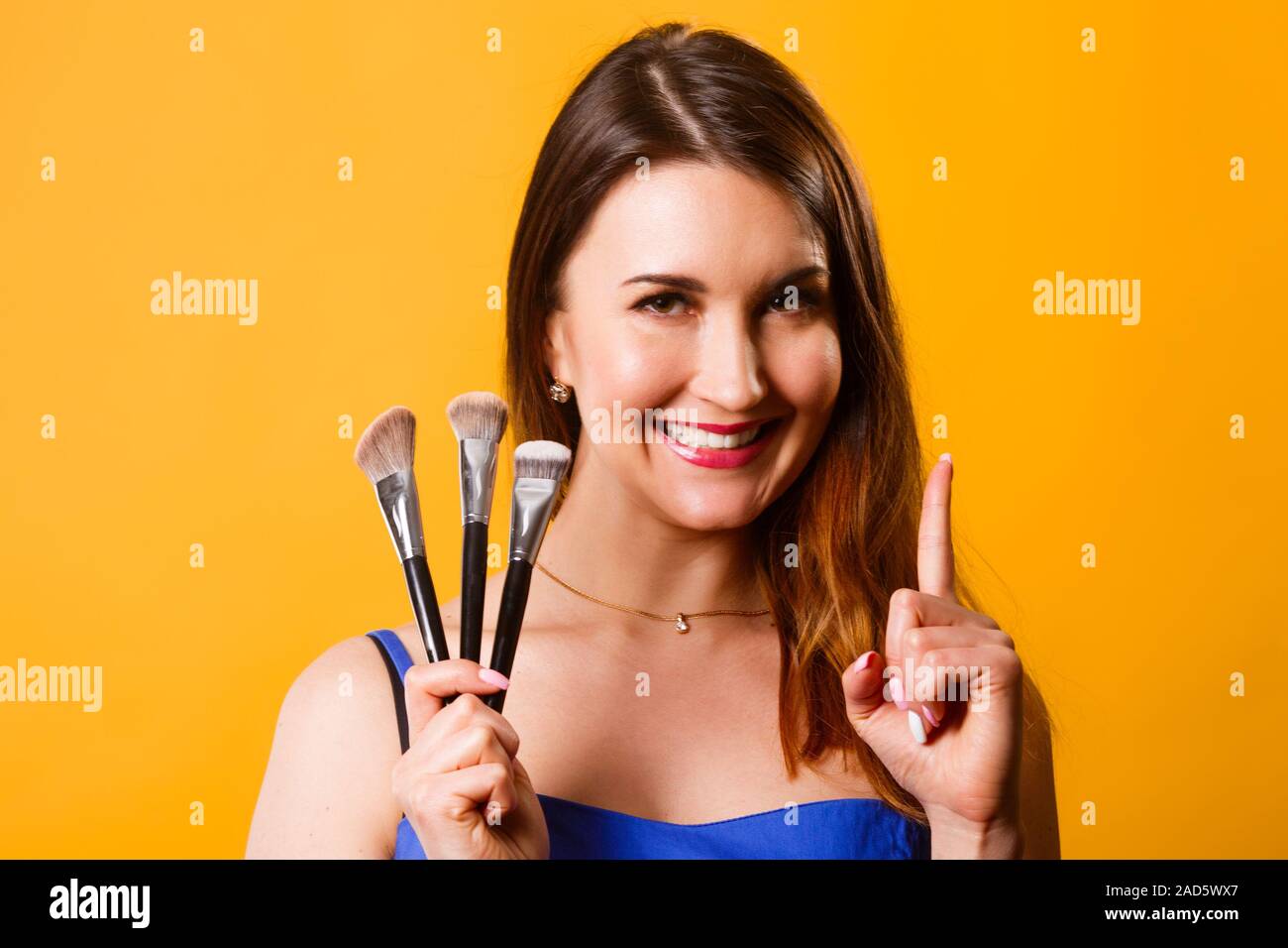 Beautiful girl with makeup brushes Stock Photo - Alamy