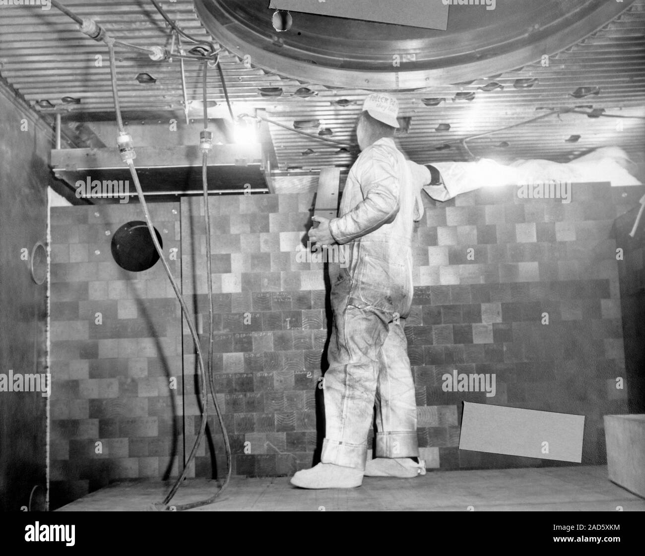 Engineering Test Reactor (ETR) installation. A worker stacks graphite ...